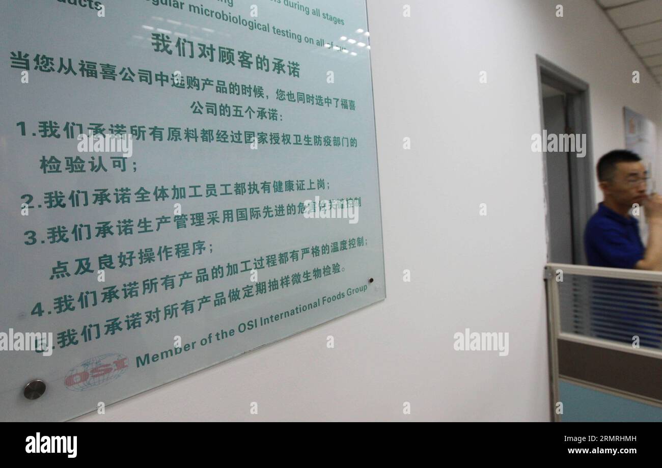 A poster shows the commitment to customers at Shanghai Husi Food Co ...