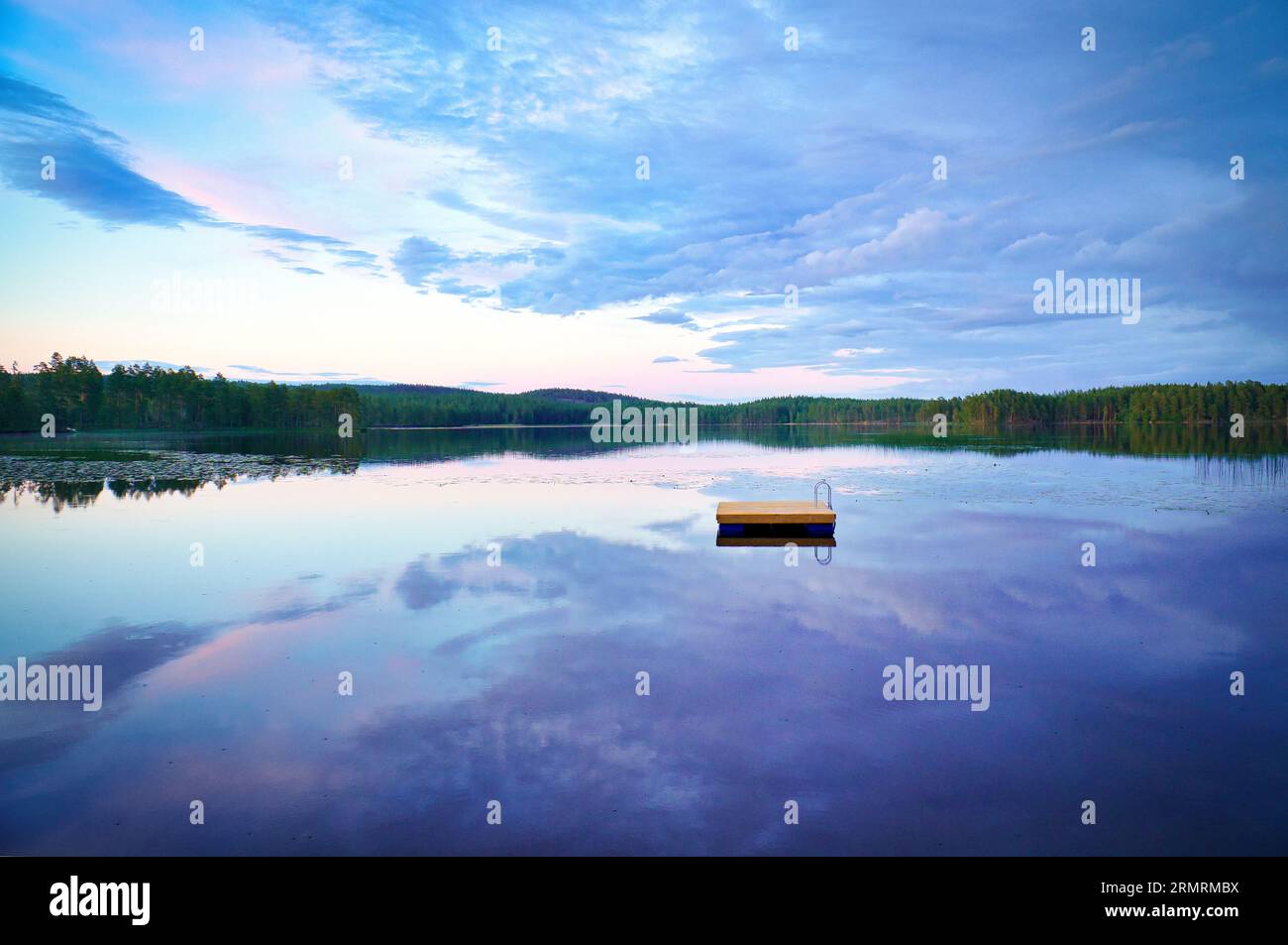 Swimming island in Sweden on a lake at sunset. Clouds reflected in the ...