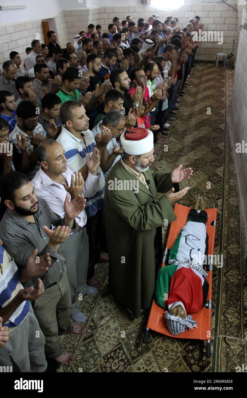 (140726) -- JENIN, July 26, 2014 (Xinhua) -- Mourners pray beside the ...