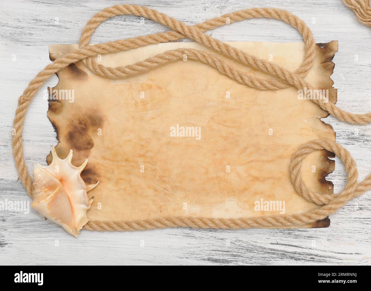 collage with parchment burnt at the edges and a rope on a wooden gray ...