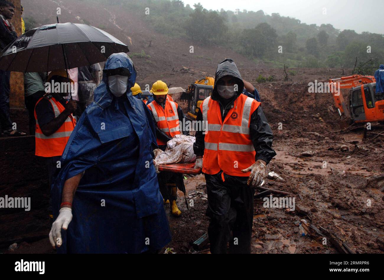 Workers from the National Disaster Management Force carry the body of a villager during the ...