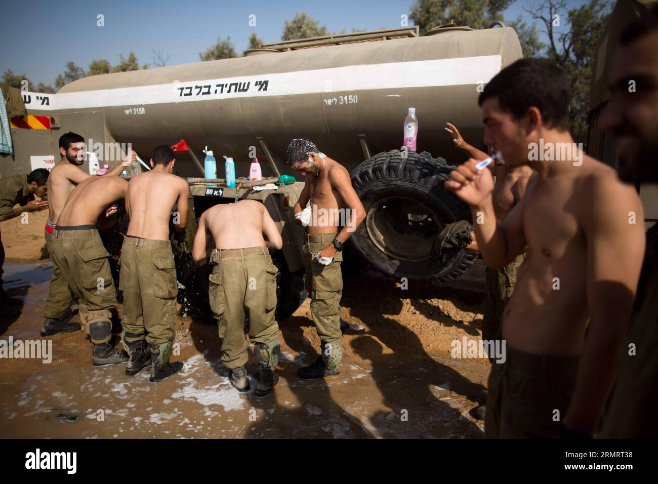 Israeli soldiers take a wash at an army deployment area in southern ...