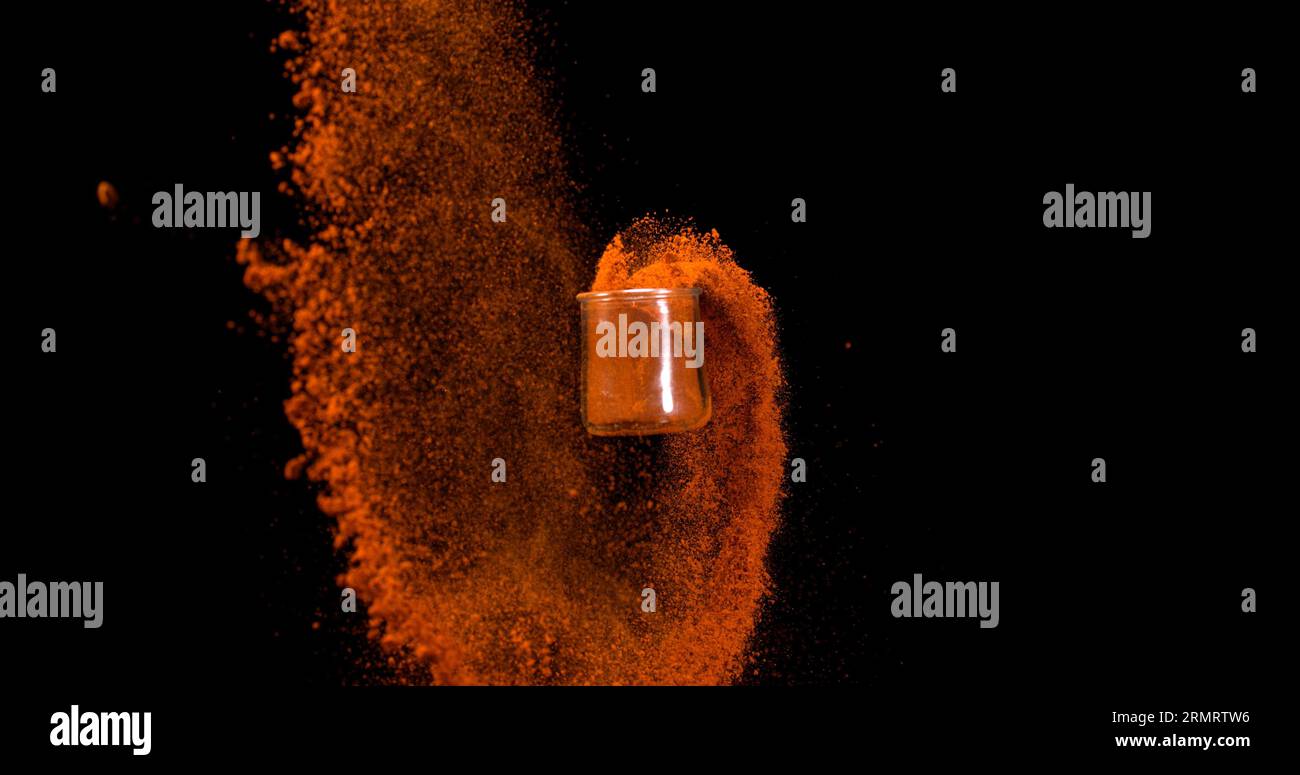 Paprika, capsicum annuum, Powder in a Small Jar falling against Black ...