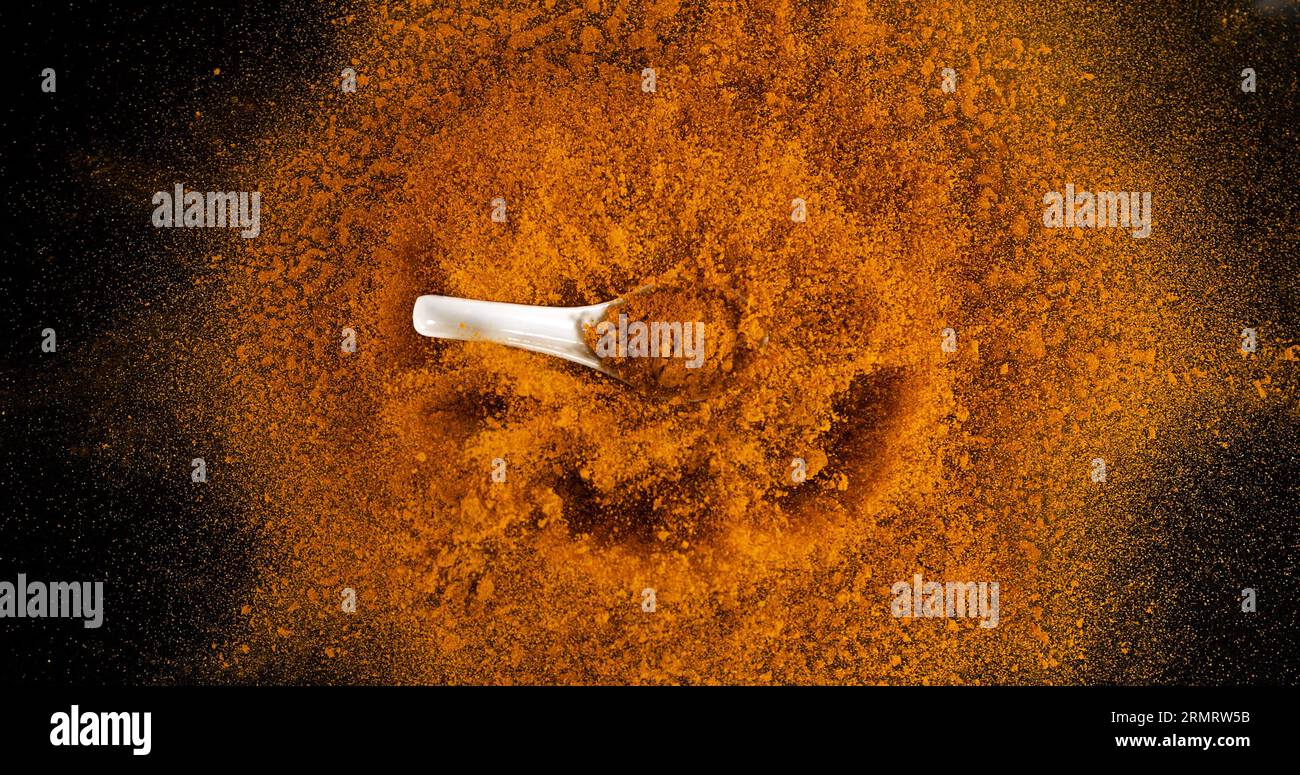 Turmeric, curcuma longa, Powder Exploding against Black Background ...