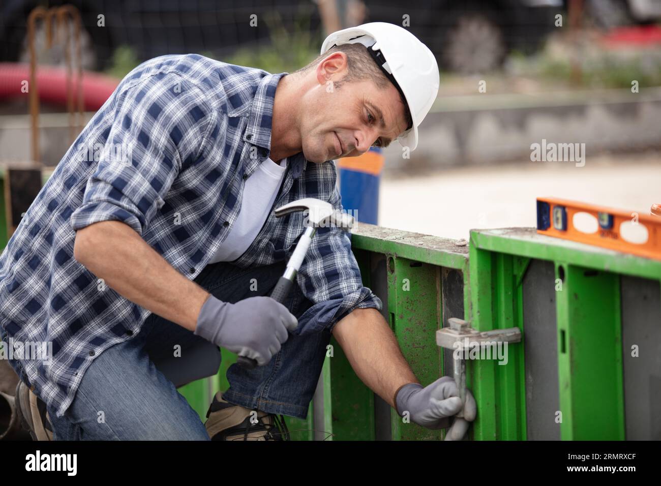 builder worker with hammer at construction site Stock Photo - Alamy