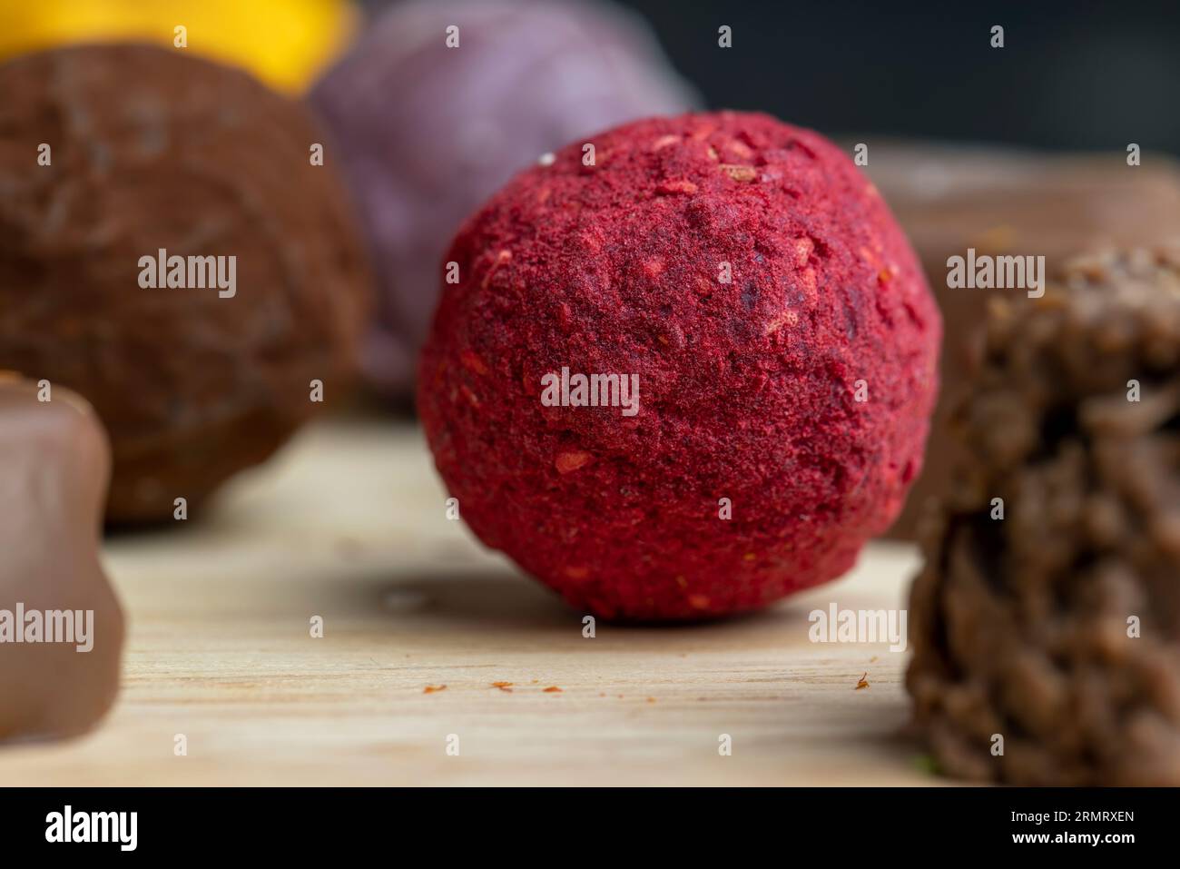 Red sweet candy in the shape of a ball on the table, chocolate candy ...
