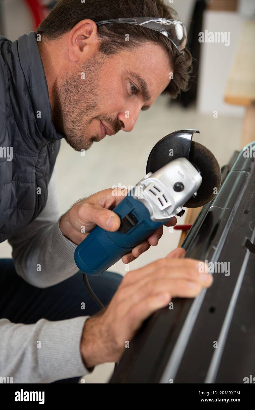 man using an angle grinder Stock Photo - Alamy