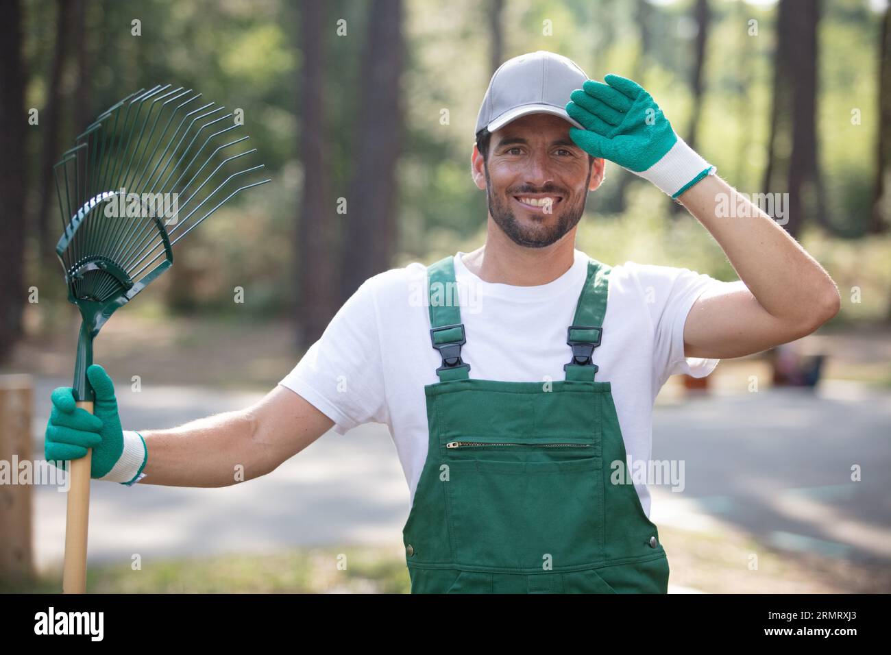 happy male gardener posing with a rake Stock Photo - Alamy