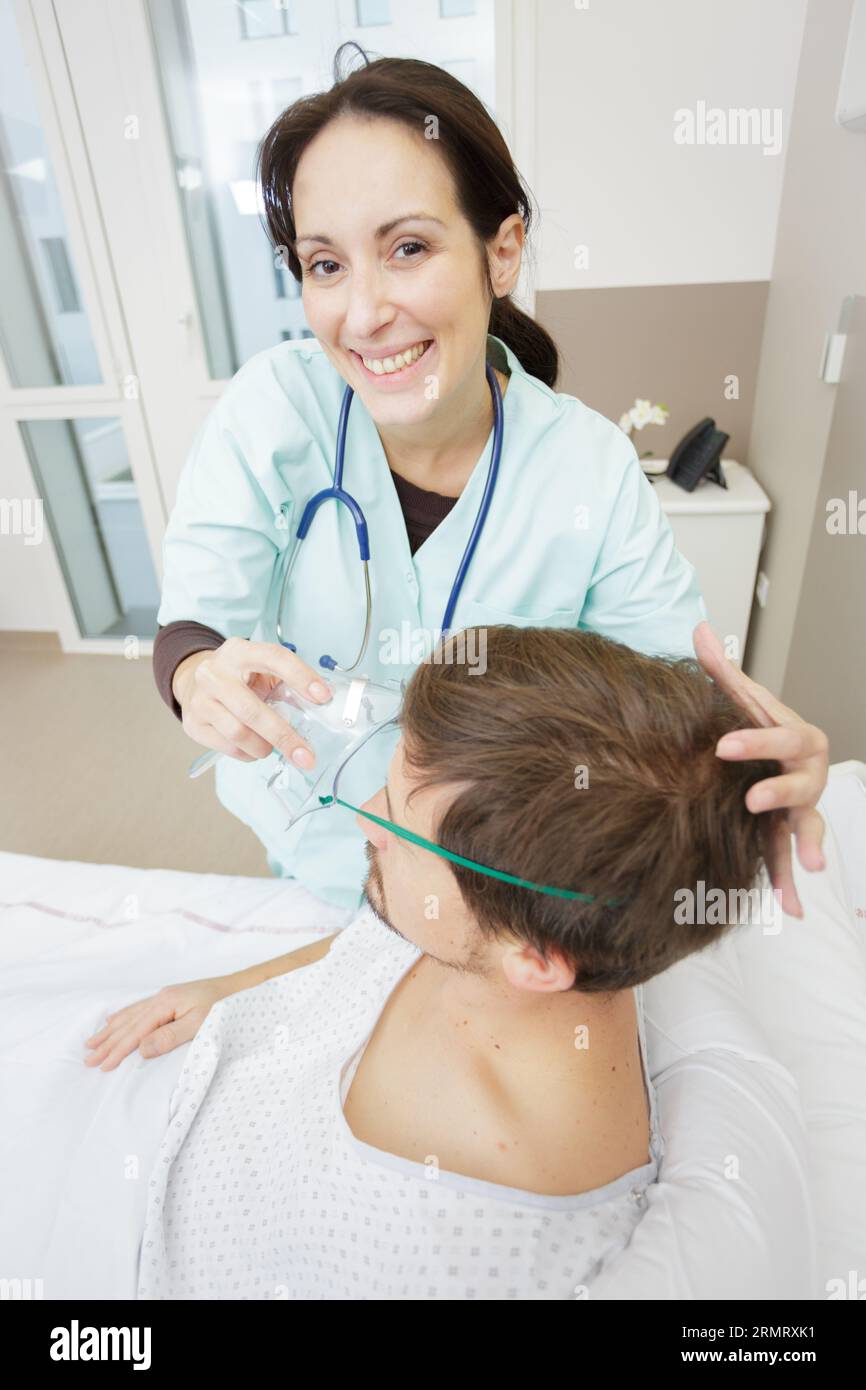 adult patient receiving oxygen treatment from happy health worker Stock ...