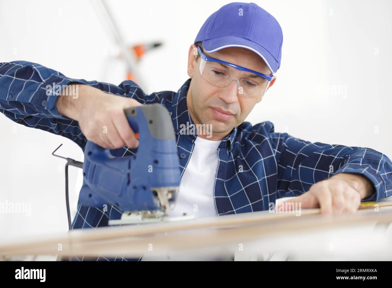 confident mature man using jigsaw Stock Photo - Alamy