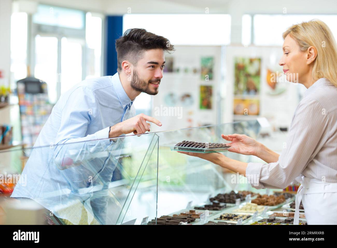young male customer buying chocolates from confectionary counter Stock ...