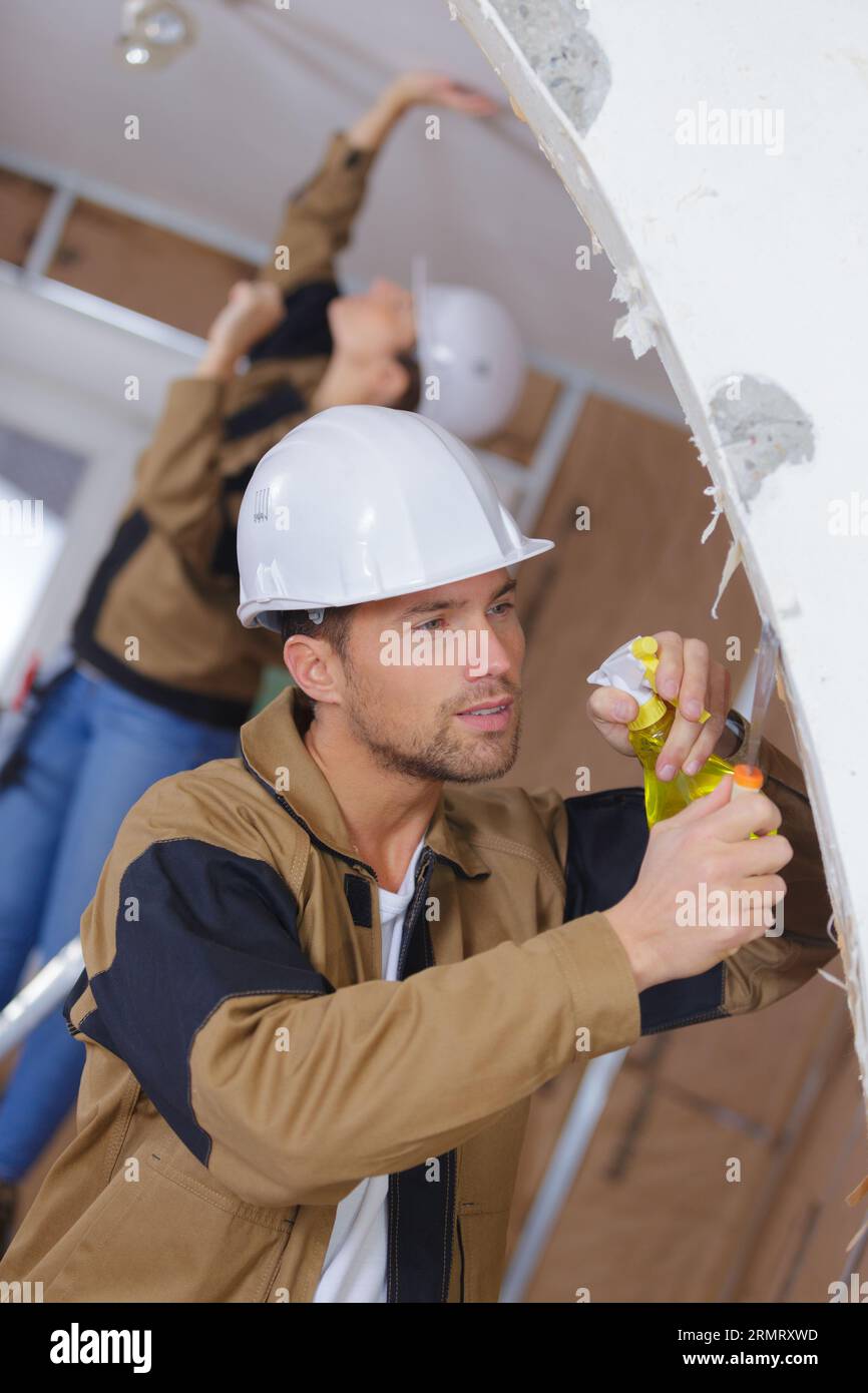 spraying the wallpaper for easy scraping Stock Photo - Alamy