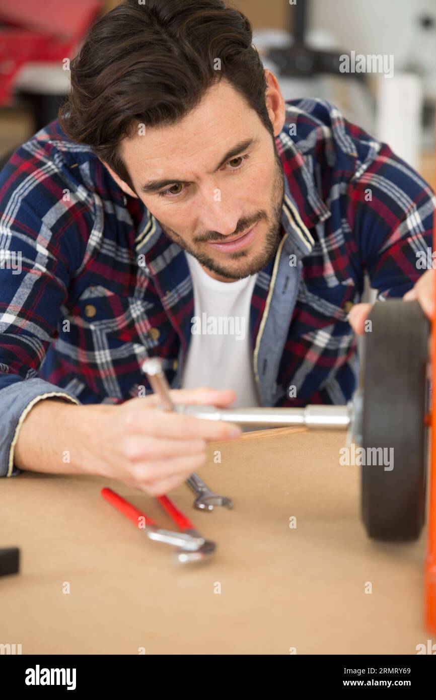 engineer repairing wheel on a sack truck Stock Photo - Alamy