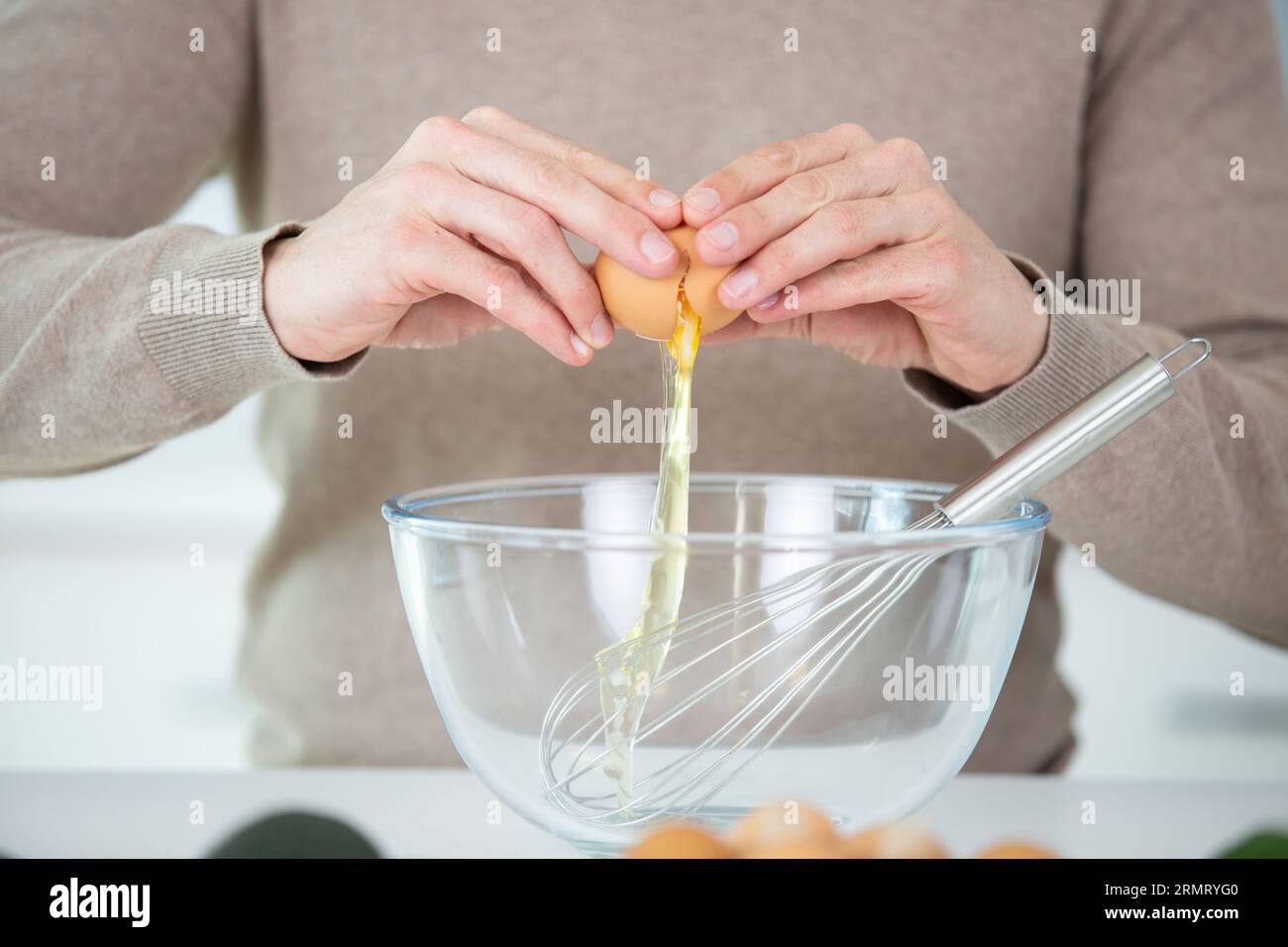 breaking an egg into a glass bowl Stock Photo - Alamy