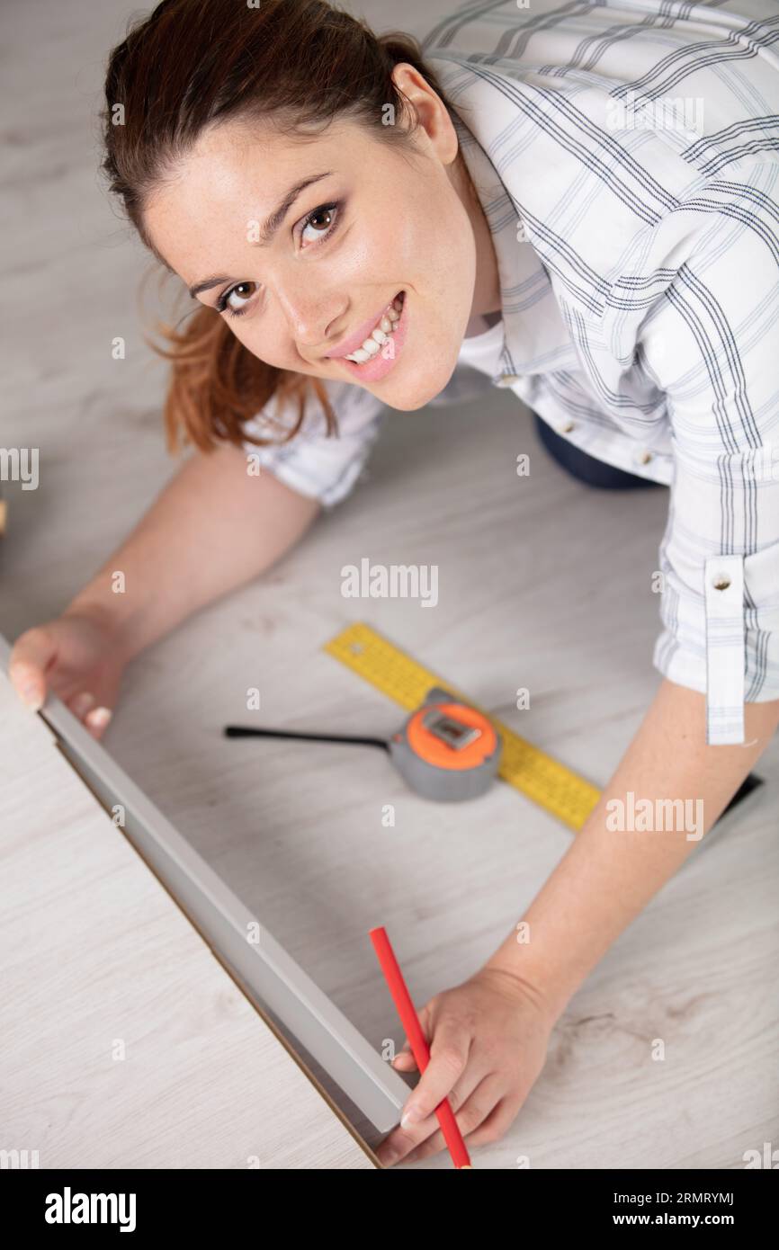 happy woman measuring the floor Stock Photo - Alamy