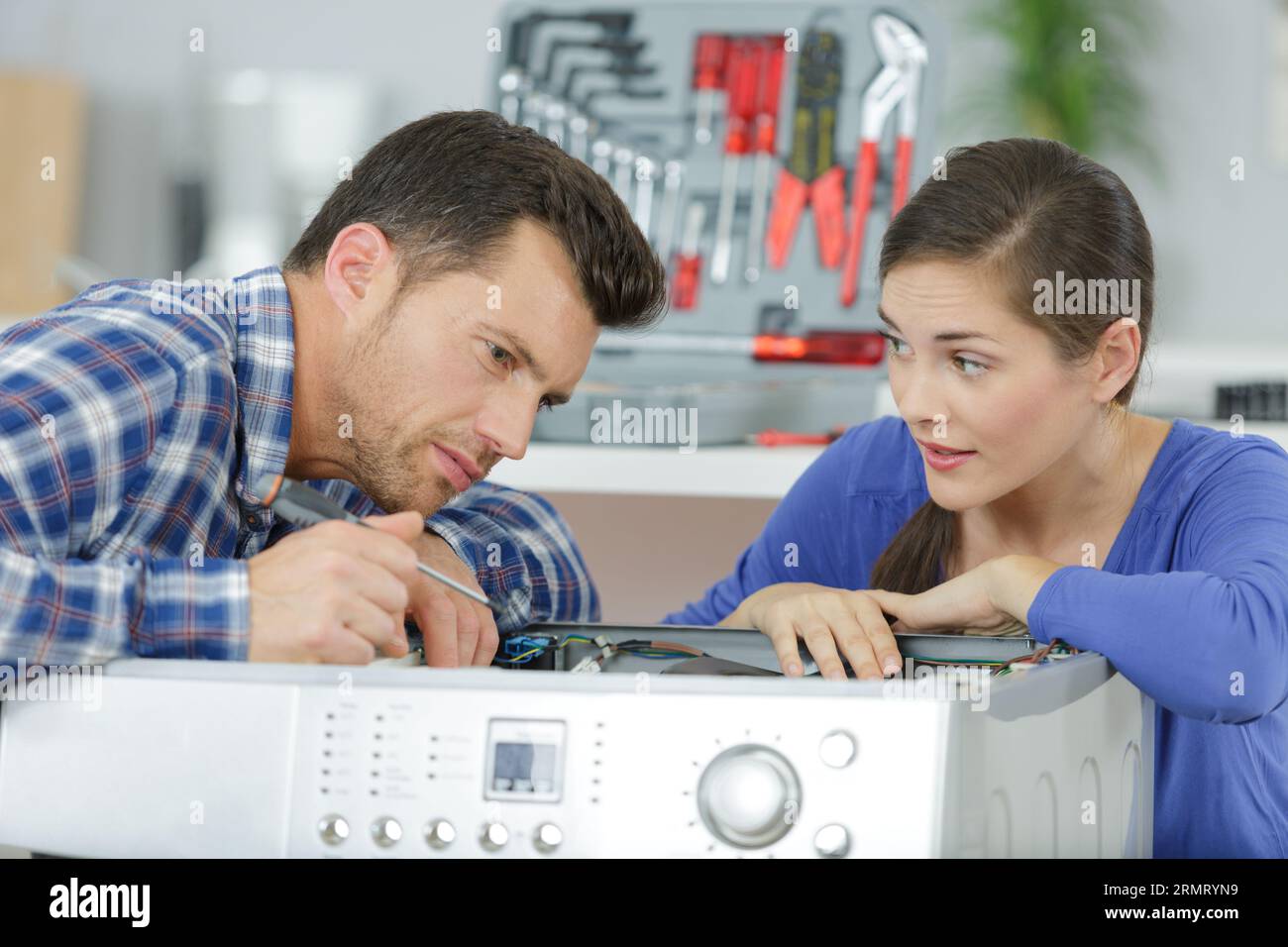Repairman woman looking washing hi-res stock photography and images - Alamy
