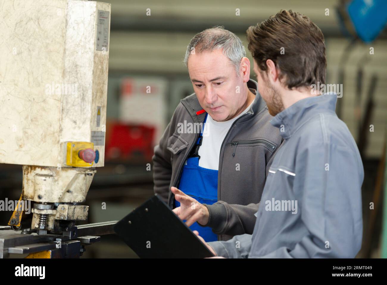 engineer showing apprentice how to use cnc tool making machine Stock ...