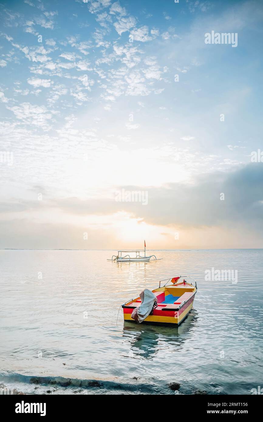 A wooden colorful traditional boat floating on the beach in the morning ...