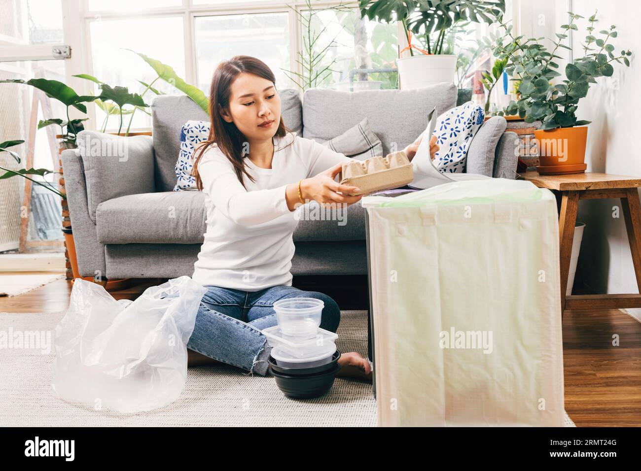 Asian female separate garbage at home. young woman sorting and ...