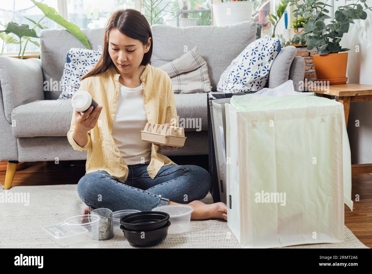 Asian female separate garbage at home. young woman sorting and ...
