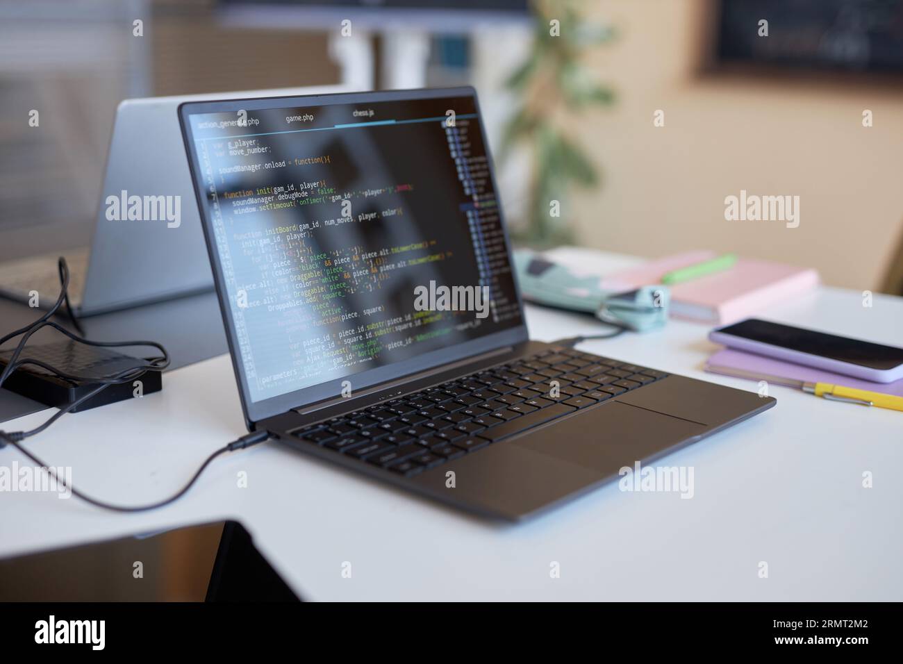 Laptop with codes on screen standing on desk of highschool student with ...