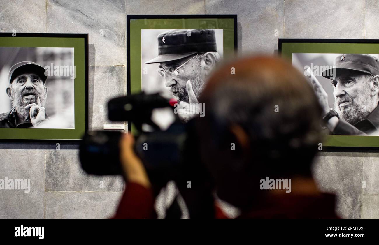 HAVANA, Aug. 12, 2014 -- A visitor takes pictures of photos of retired ...