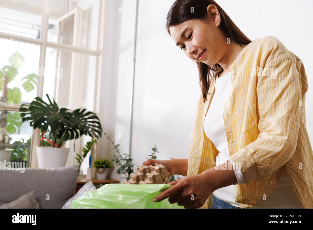 Asian female separate garbage at home. young woman sorting and ...