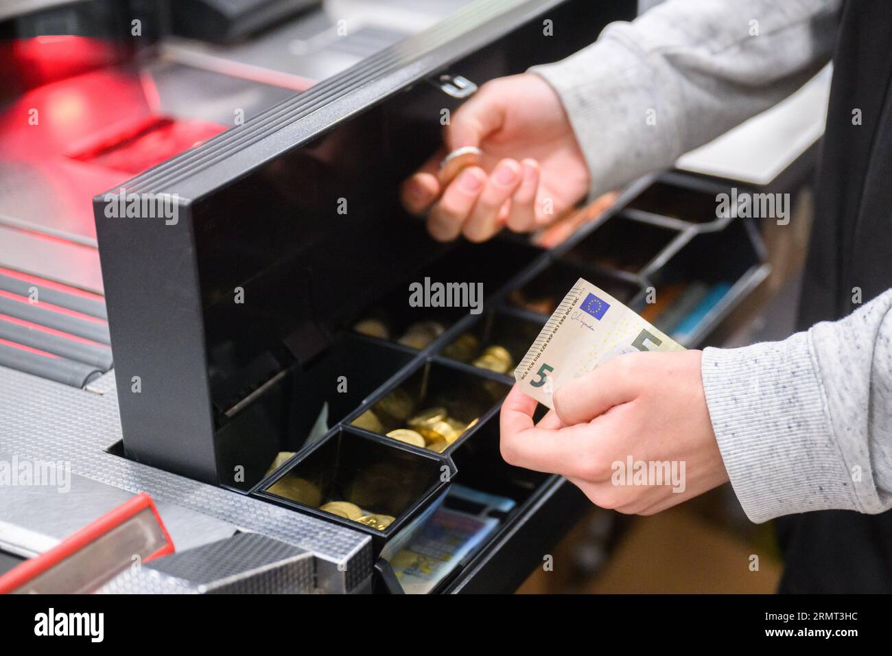 Hanover, Germany. 30th Aug, 2023. A cashier takes change from the cash ...