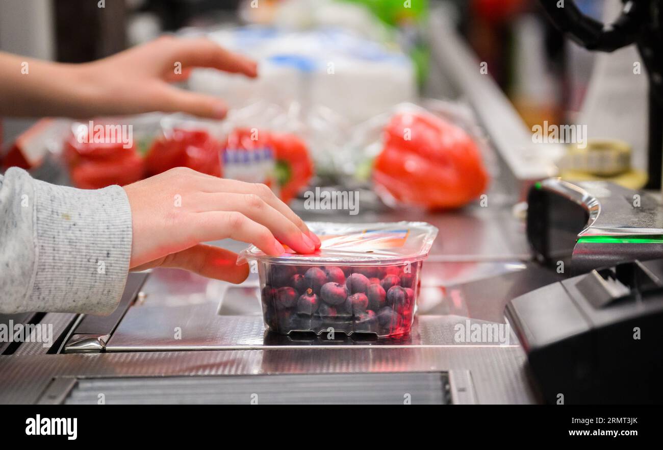 Hanover, Germany. 30th Aug, 2023. A cashier scans blueberries at a ...