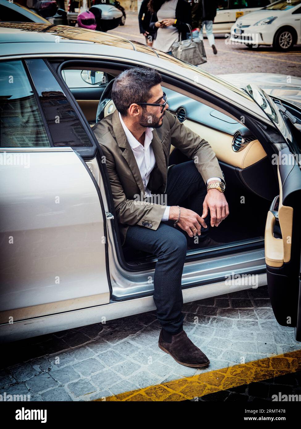 A man in a suit sitting in a car. Photo of a man in a suit sitting in a ...