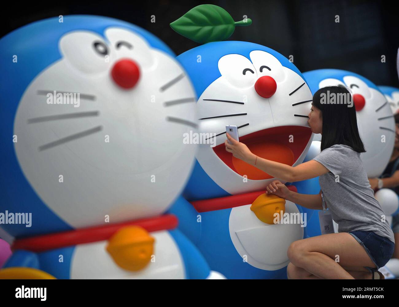 (140816) -- CHENGDU, Aug. 16, 2014 -- A visitor takes a selfie with a Doraemon figure during a ...