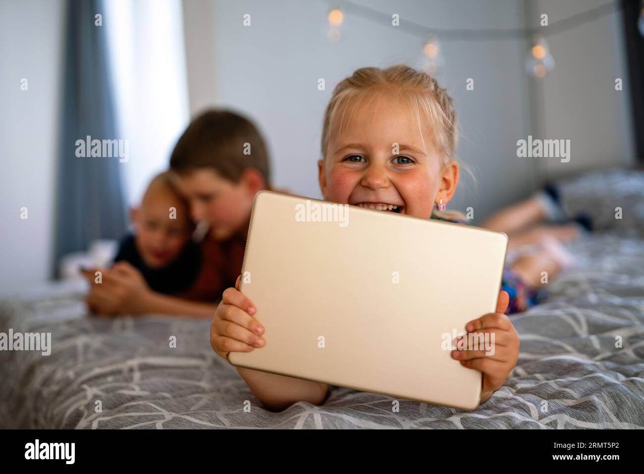 Portrait of happy children using digital devices and having fun ...