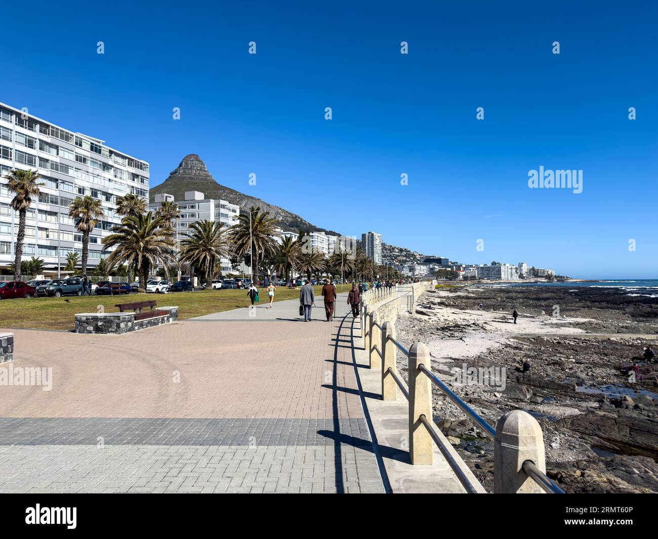 A walk along the Sea Point Promenade in Cape Town with Lions Head in ...