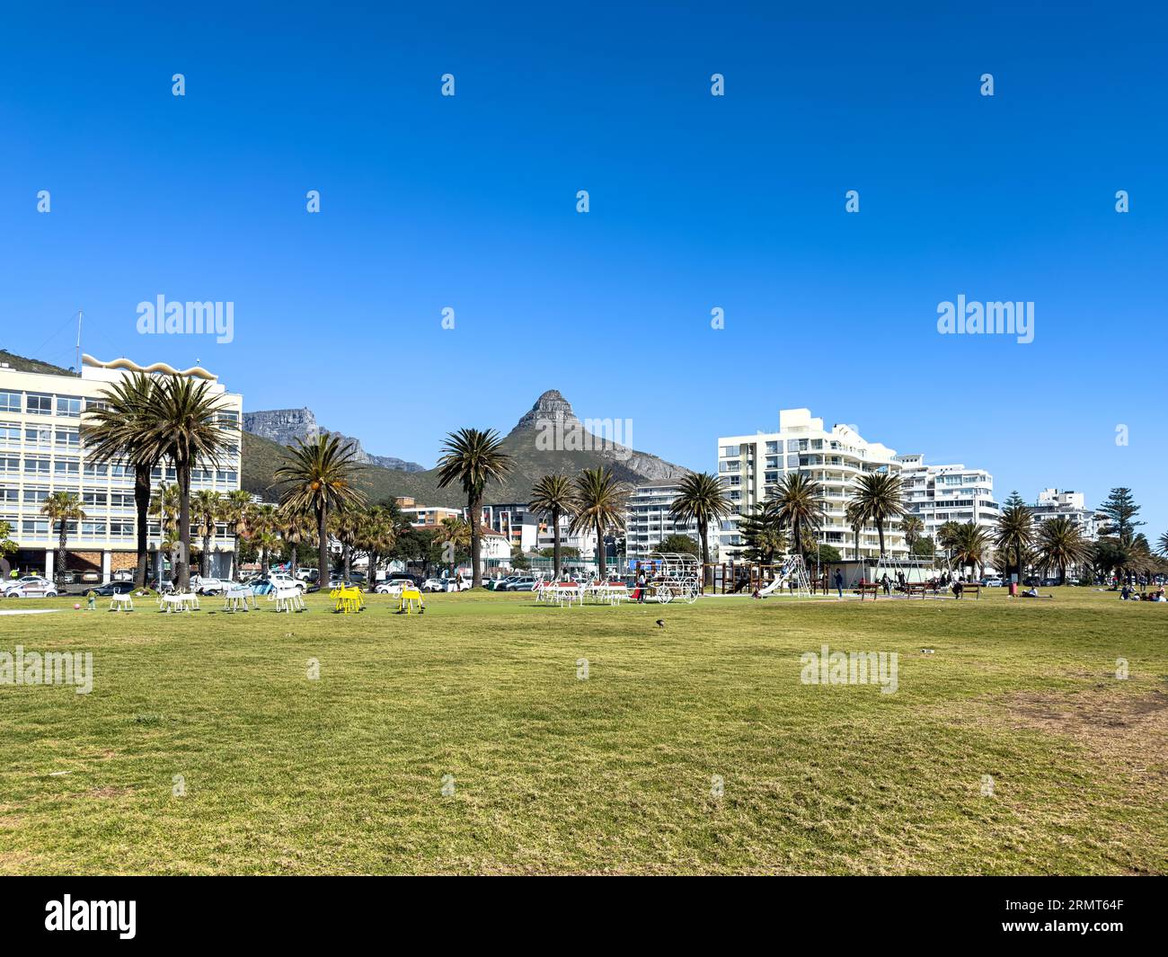 A walk along the Sea Point Promenade in Cape Town with Lions Head in ...