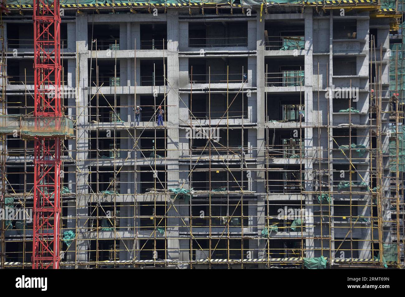 Builders work at the construction site of residential buildings in ...
