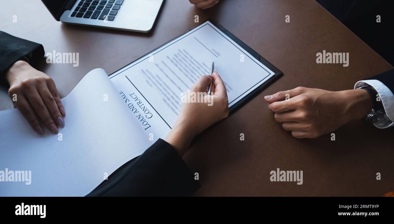 Solicitor pointing at insurance contract showing male client where to ...