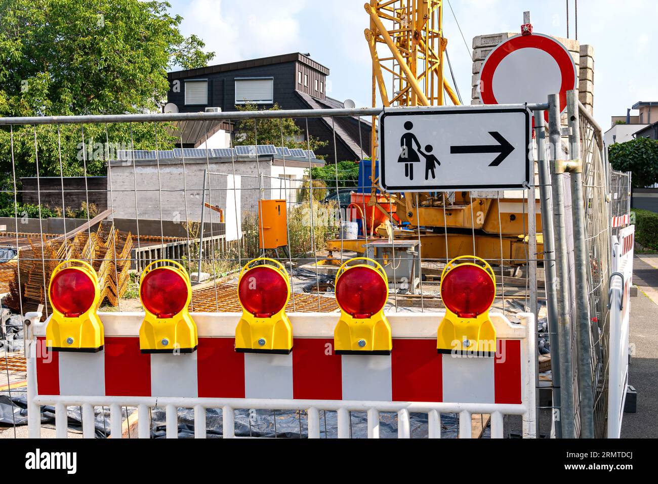 Construction site with tower crane fenced with white and red barriers ...