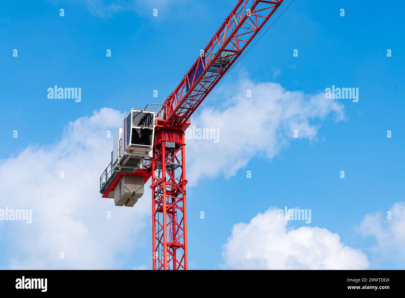 A fragment of a red tower crane with a driver's cab and a counterweight ...