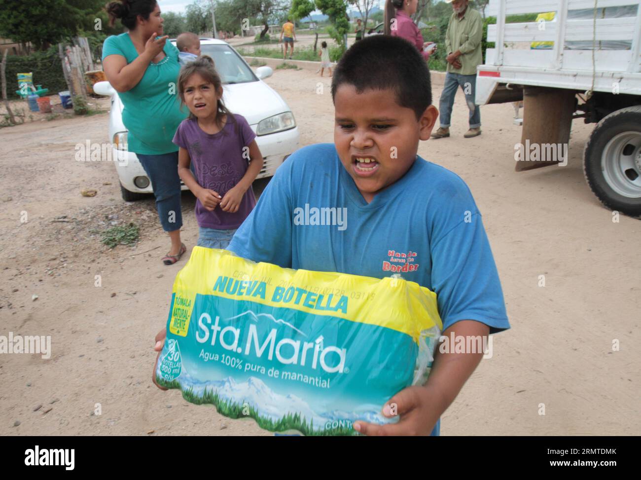 Image taken on Aug. 19, 2014, of a boy carrying a package of purified ...