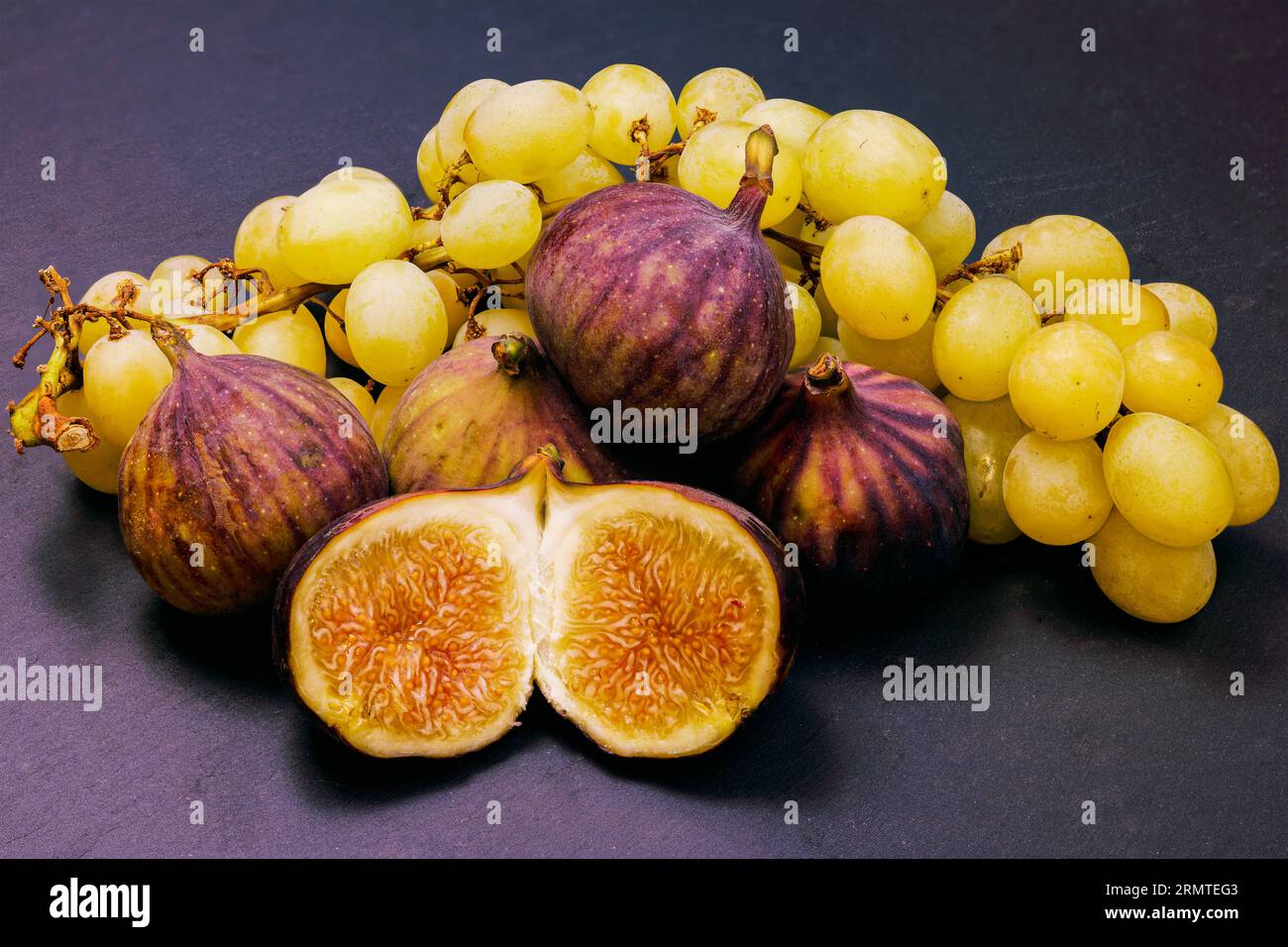 figs and grapes on a stone plate isolated Stock Photo - Alamy