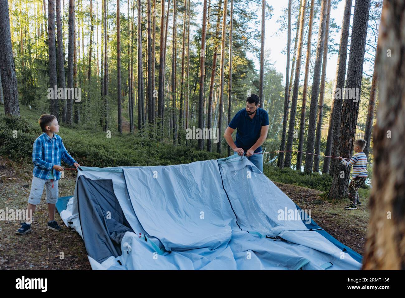 children helping father to put up a tent. Family camping concept Stock ...