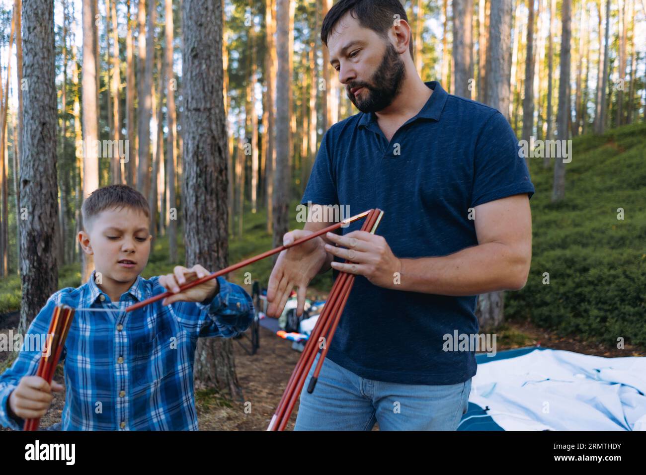 cute caucasian boy helping father to put up a tent. Family camping concept Stock Photo - Alamy