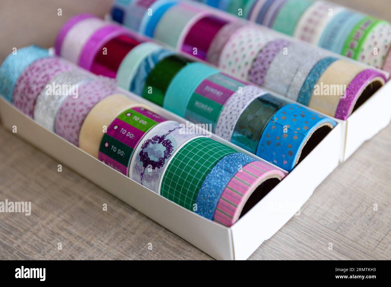 A portrait of a box full of colorful rolls of washi tape having ...