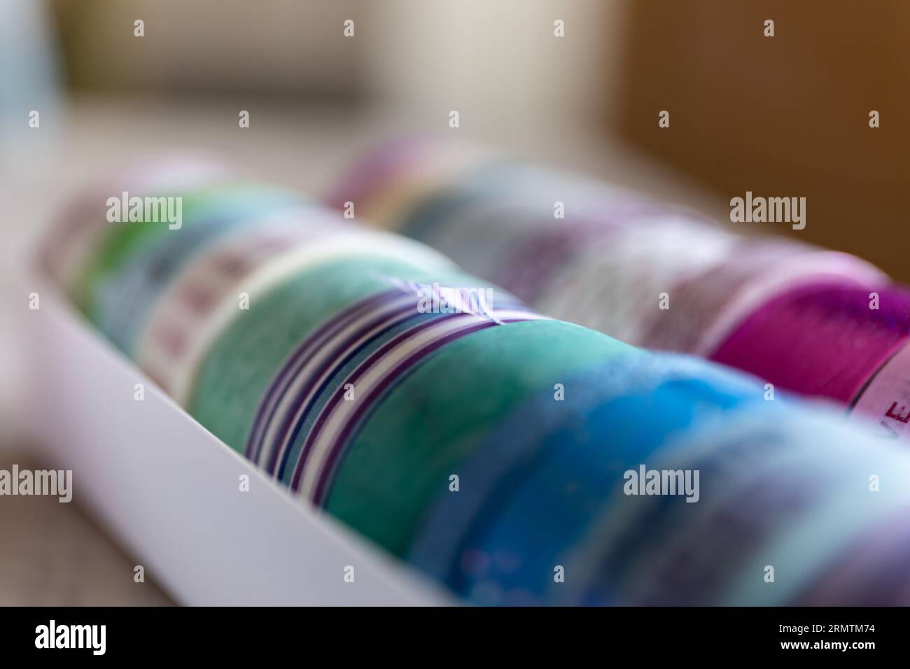 A closeup of colorful washi tape in different patterns and colors in a ...