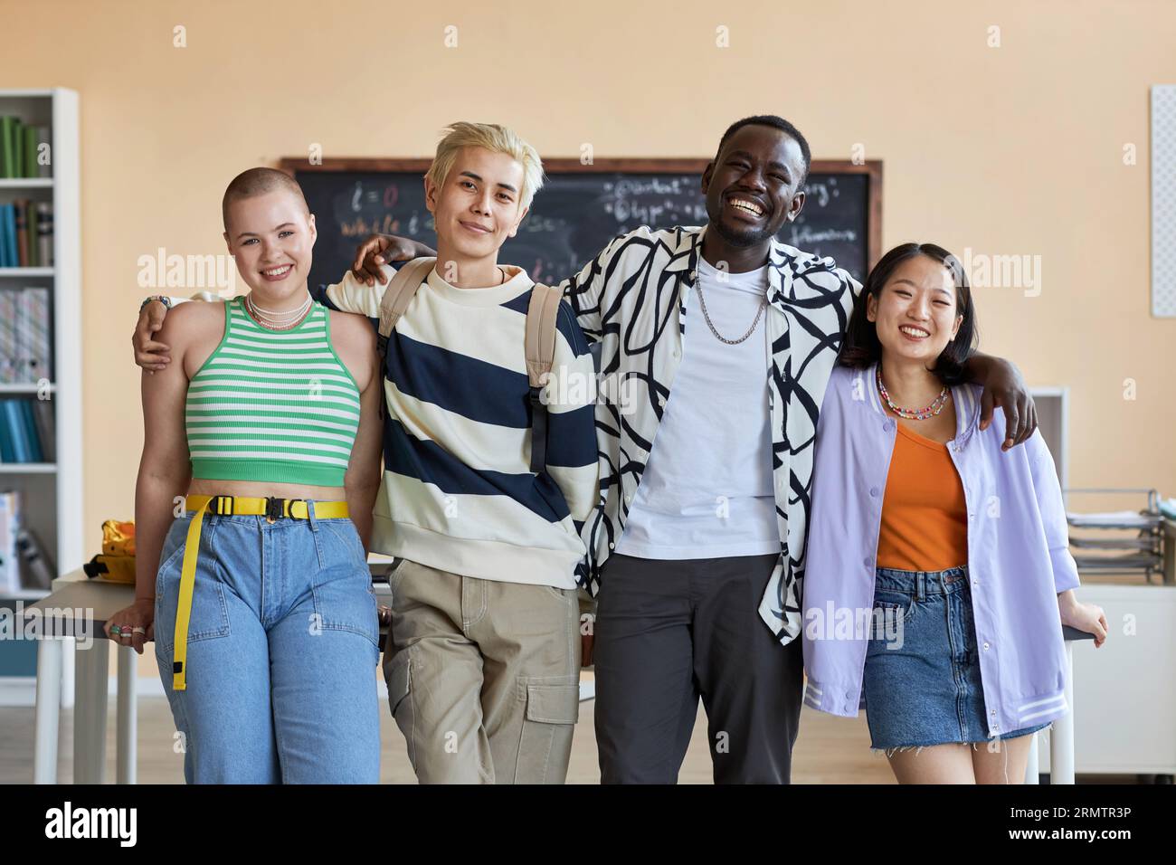 Team of cheerful friendly learners of highschool looking at camera ...