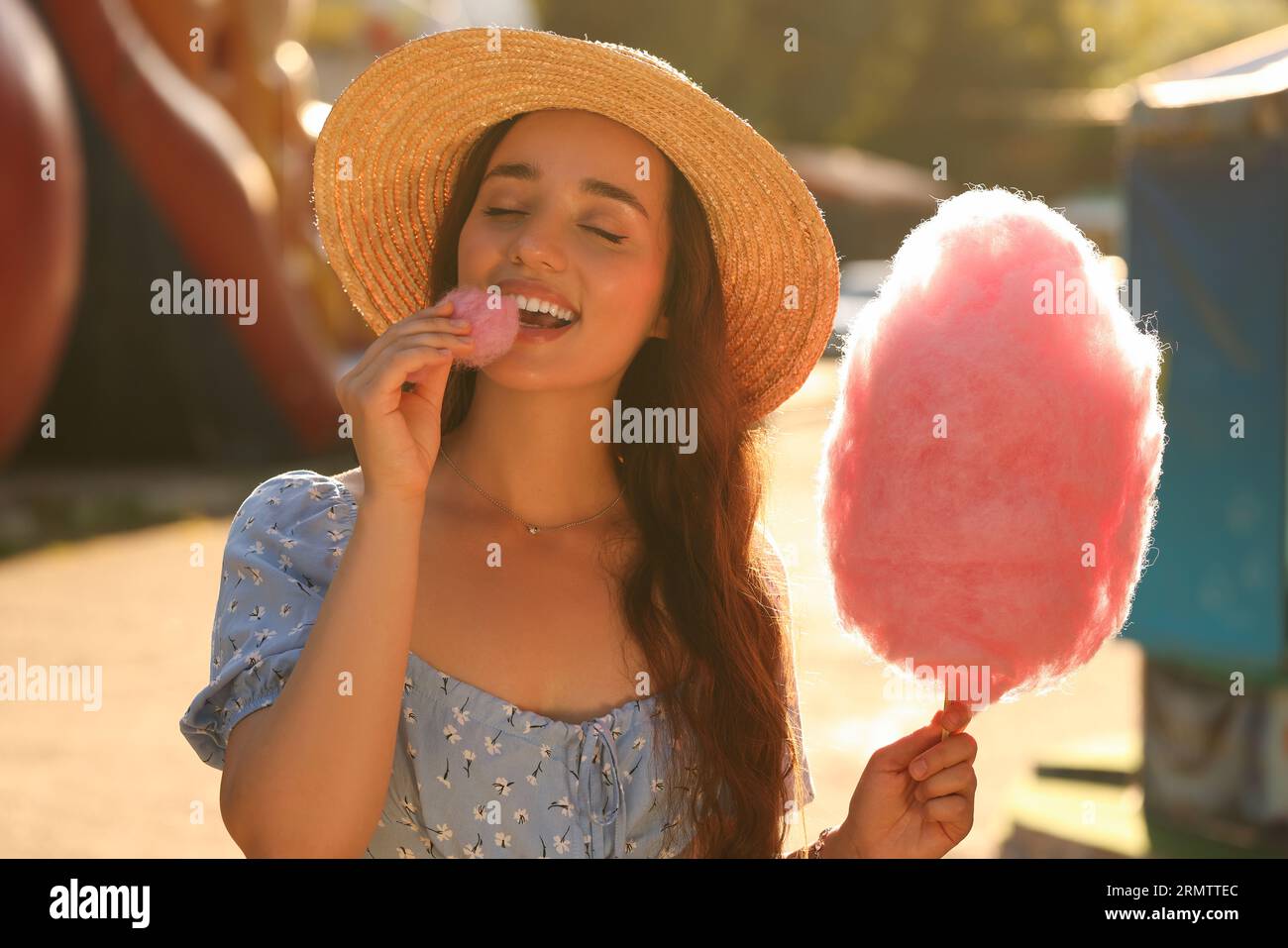 Beautiful young woman eating cotton candy outdoors on sunny day Stock ...