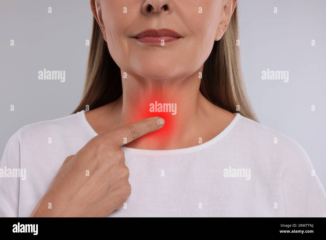 Endocrine system. Woman doing thyroid self examination on light grey ...
