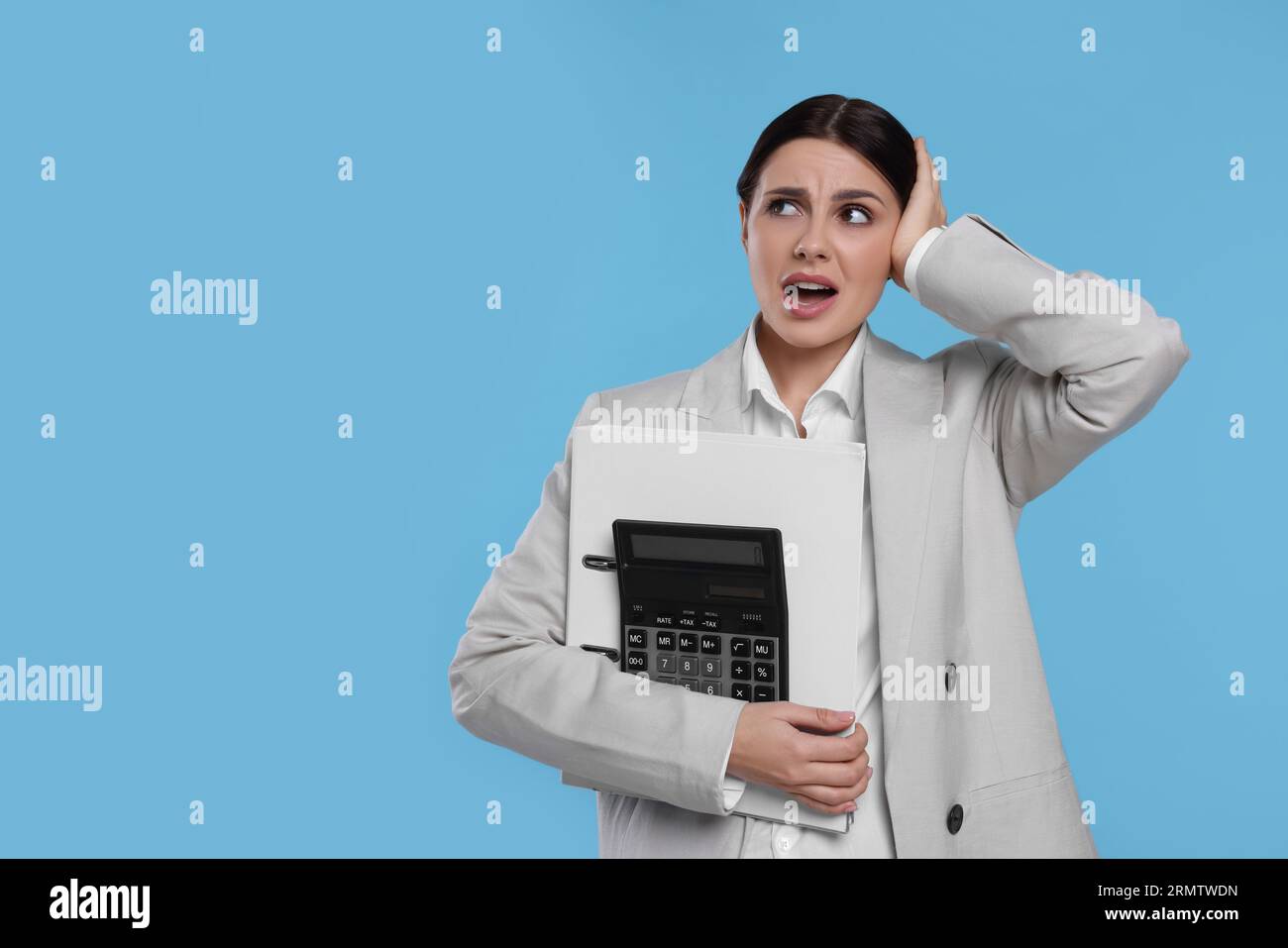 Emotional accountant with calculator and folder on light blue ...