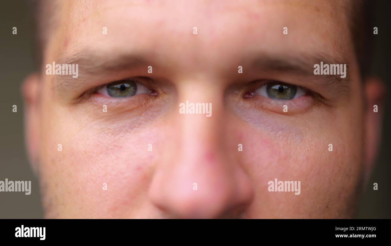 Extreme close up of handsome young man face looking at camera and ...