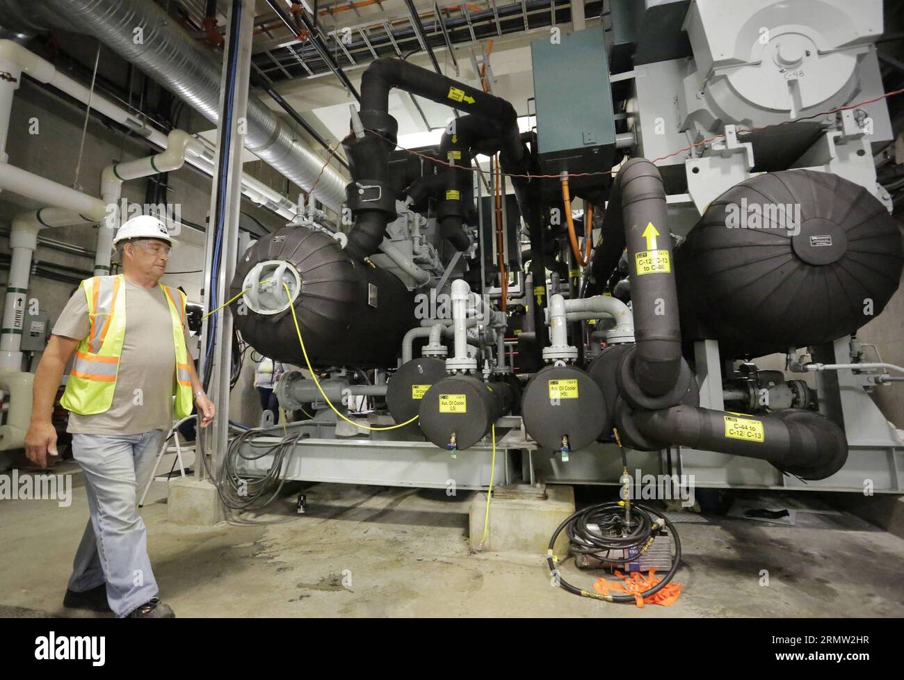 A worker works at the heat pump located inside the Neighbourhood Energy ...